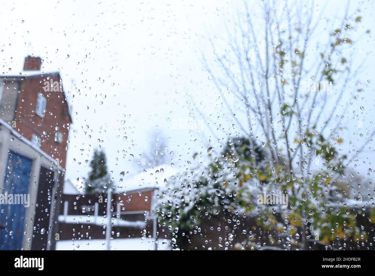 Rain and melting snow on window with back yard in background Stock ...