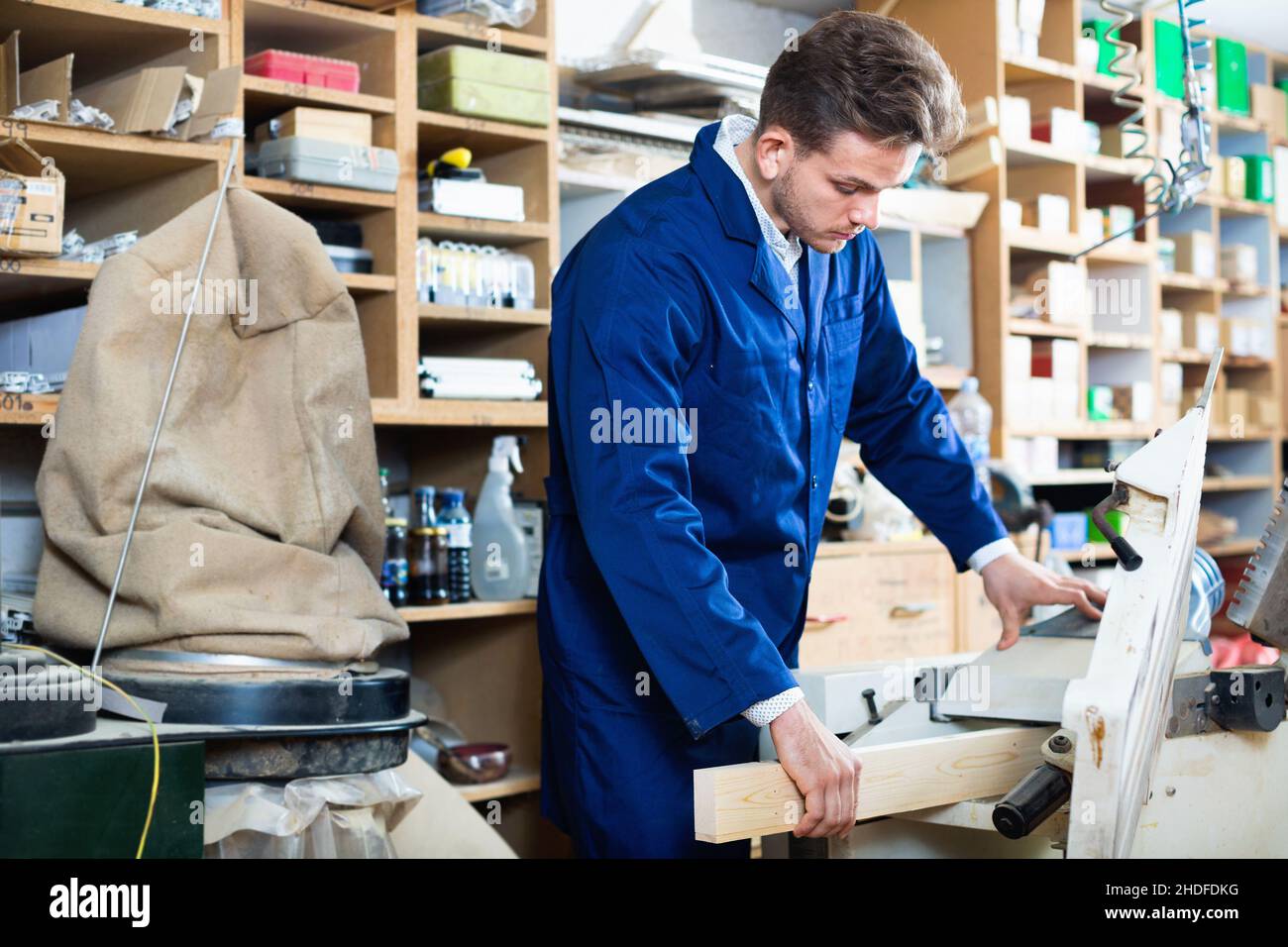 Young guy using machine to process plank Stock Photo - Alamy