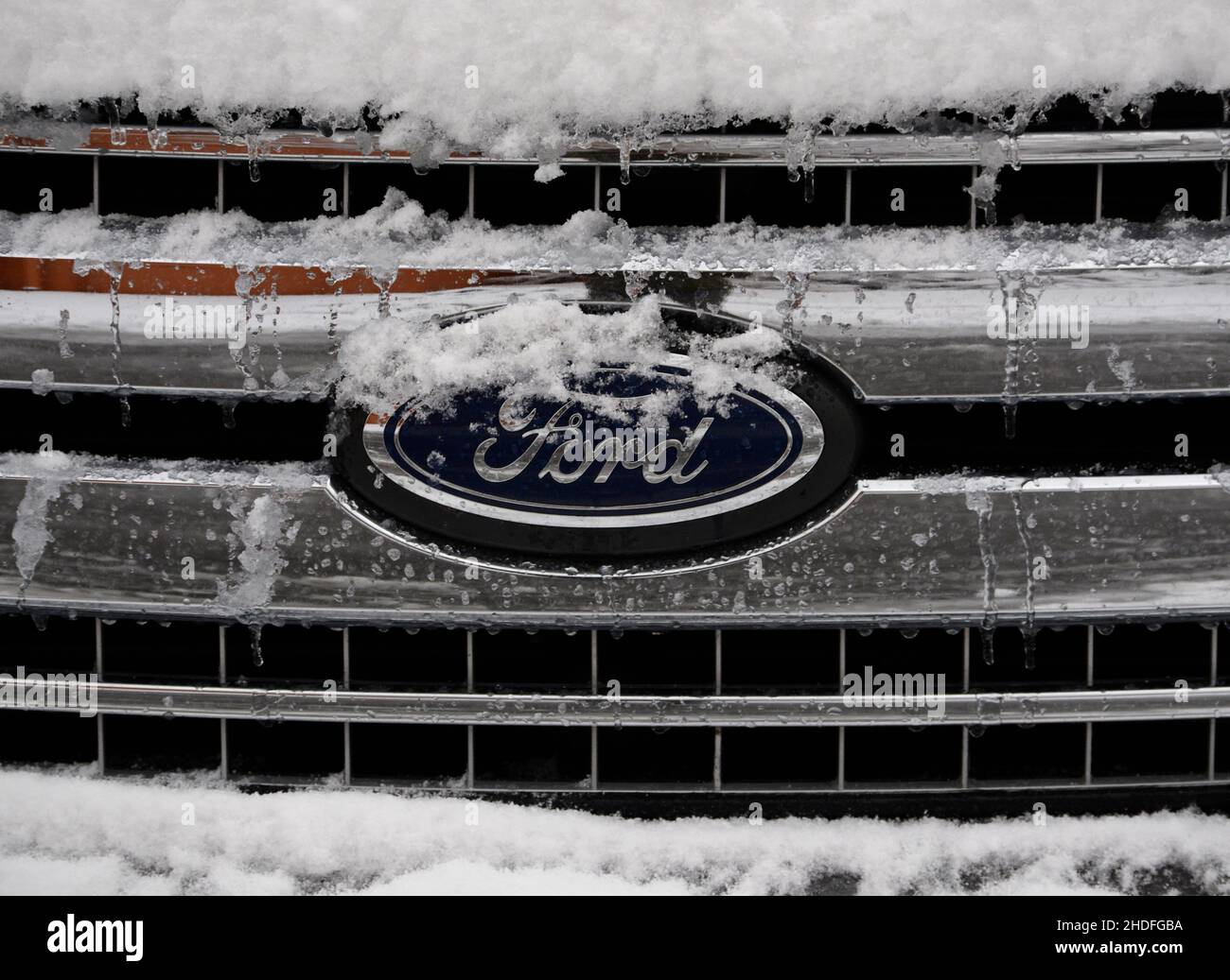 The familiar Ford logo on the grill of a Ford truck after a snow storm ...