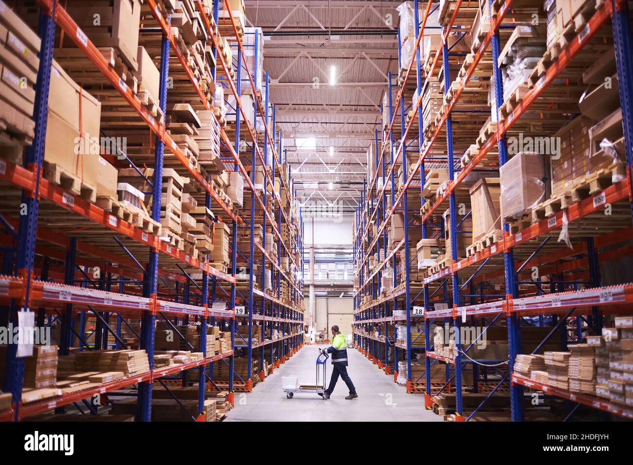 Male warehouse worker pulling a pallet truck Stock Photo - Alamy