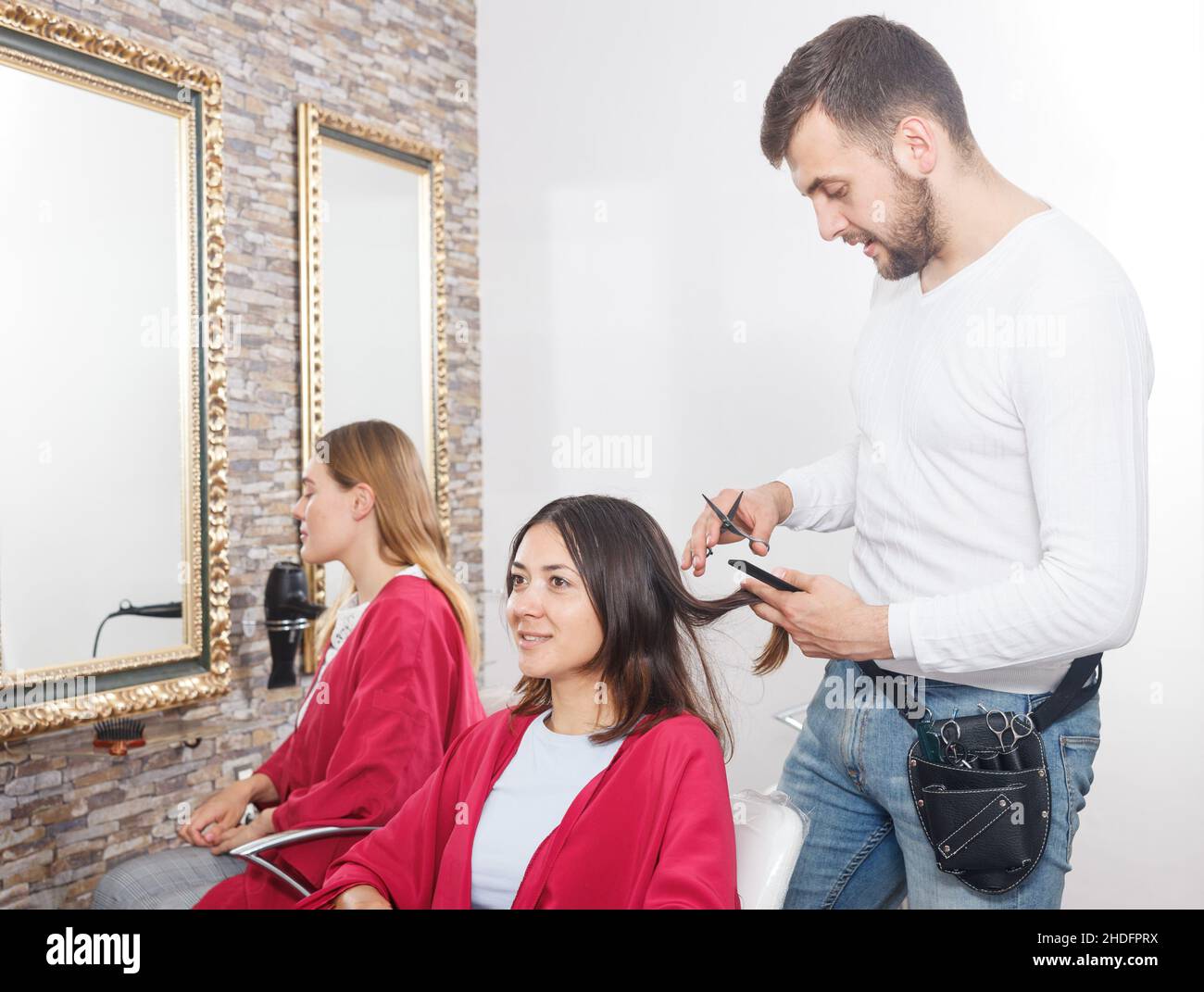 Young man professional hairdresser cut female's hair in salon Stock ...