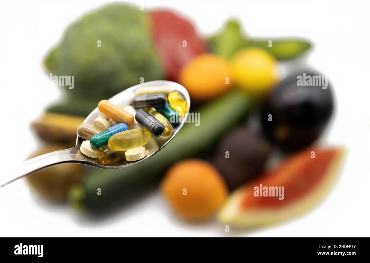 Capsules and pills of nutritional supplements and fresh vegetables and ...