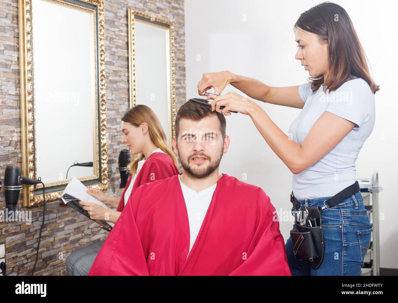 Woman professional hairdresser cut male's hair in hairdressing salon ...