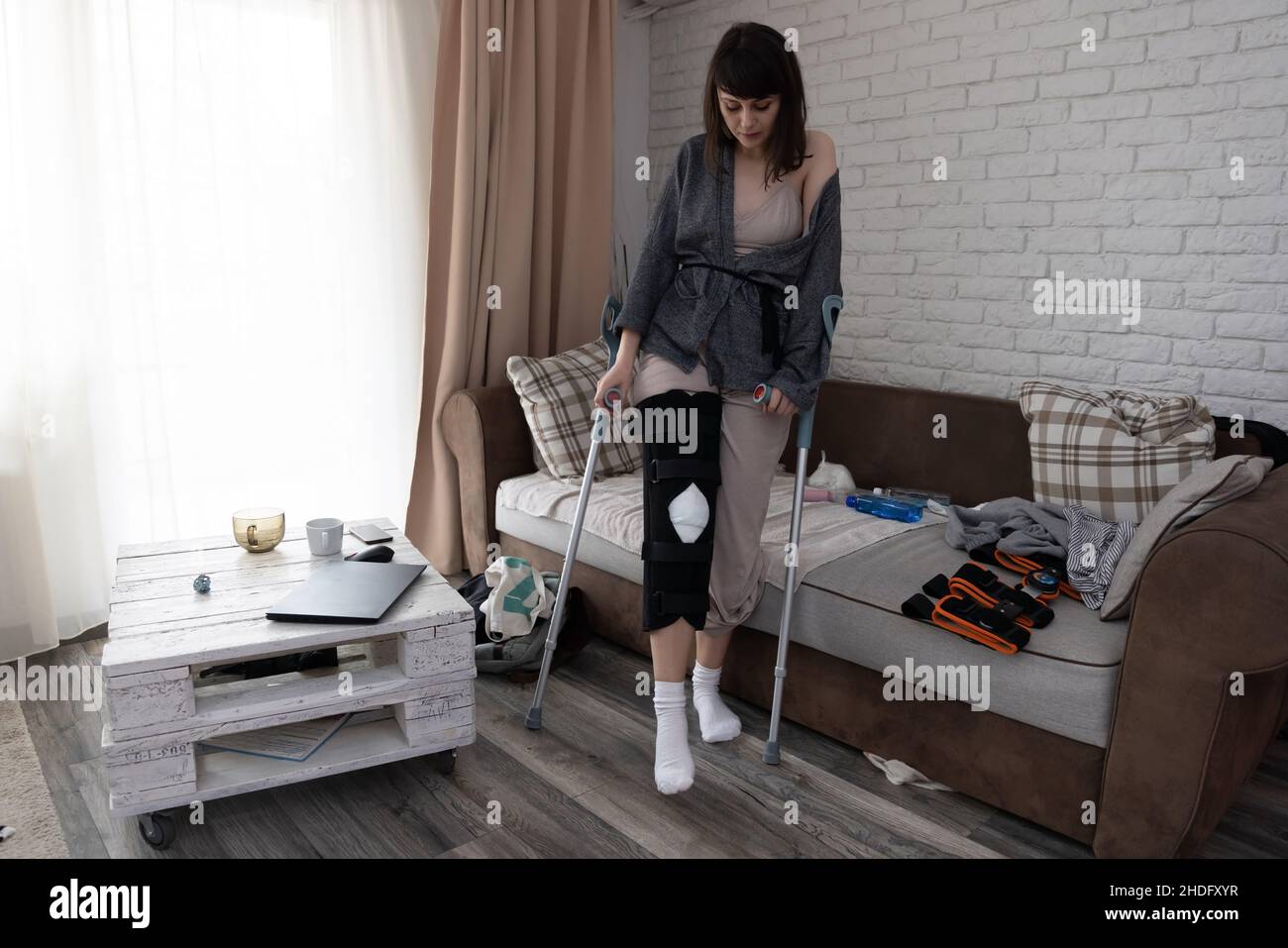 Young woman at home recovering from an ACL surgery Stock Photo - Alamy