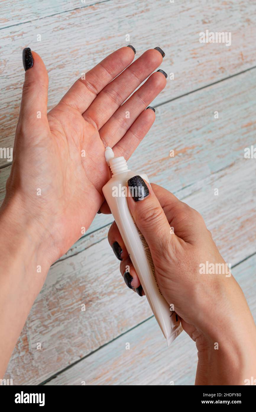 woman's hand squeezes out the cream from the tube Stock Photo - Alamy