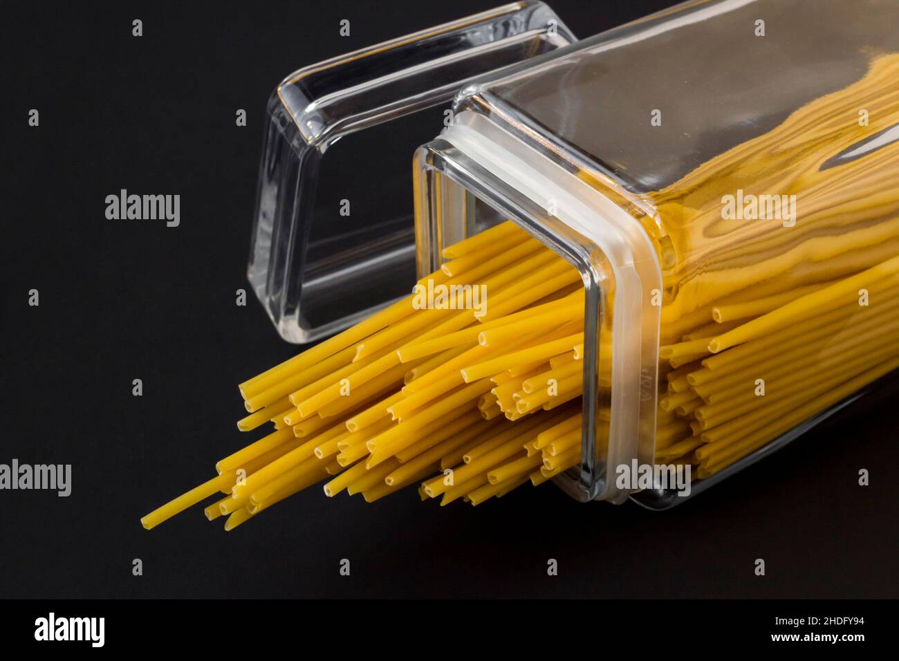 Uncooked,dry various sizes of spaghetti pasta in long glass jar on ...