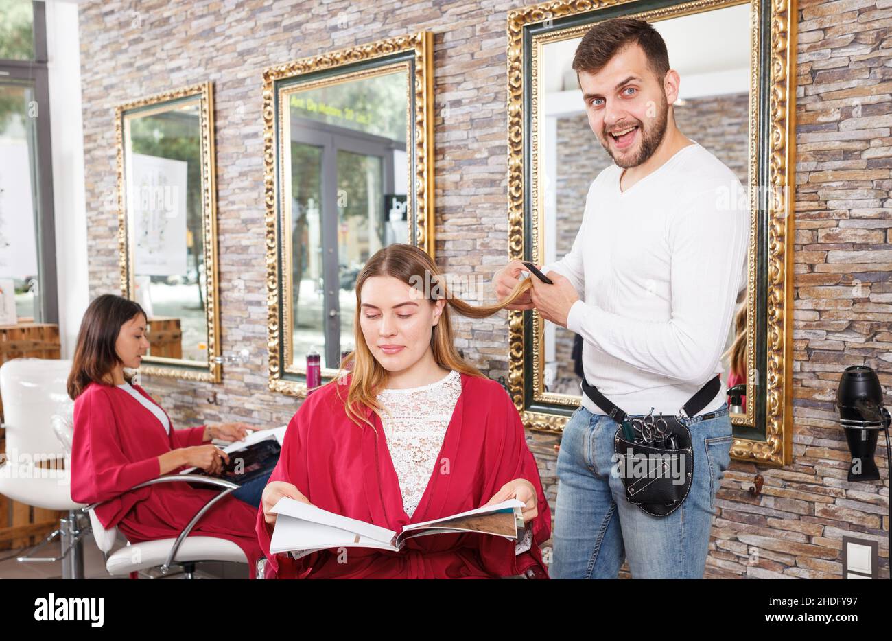 Adult hairdresser working with female client in hairdressing salon ...