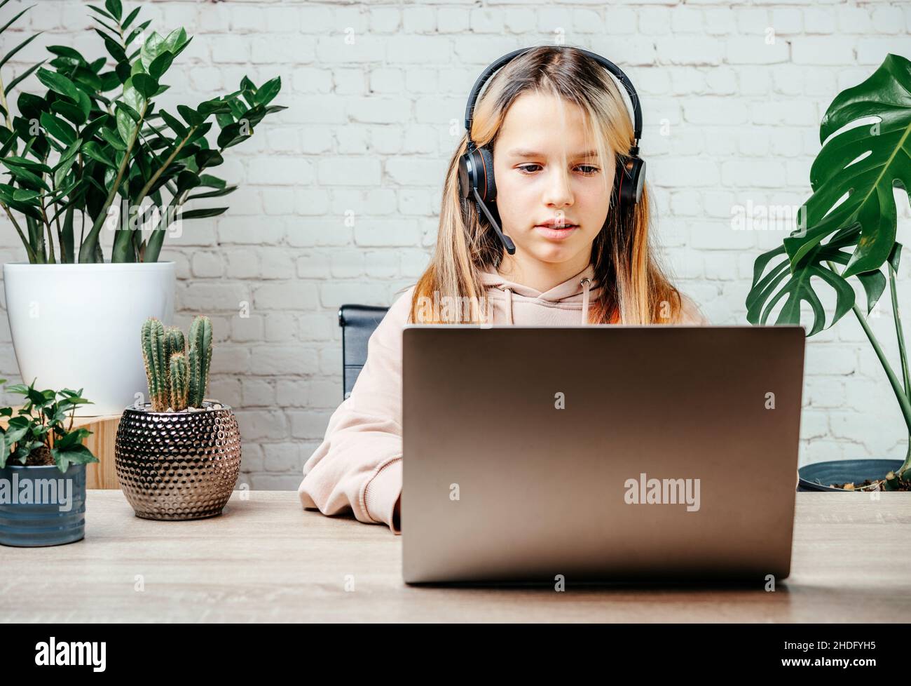 Student girl in headphones watching online video zoom class webinar in ...