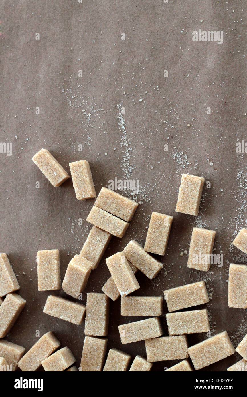 Brown colored,sugar cubes on kraft paper with grain of sugar and copy ...