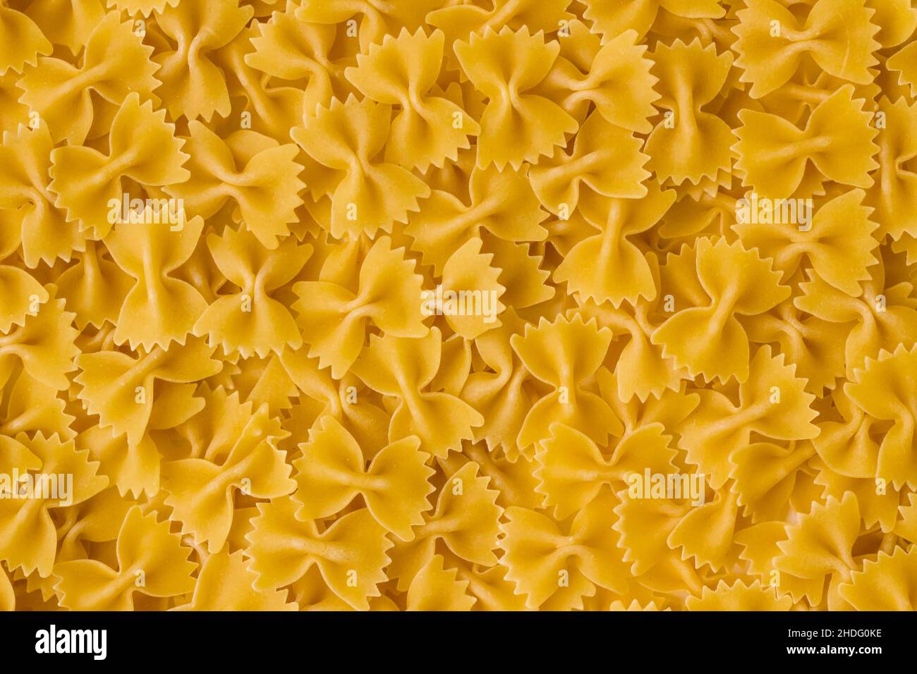 Uncooked,dry bow shaped pasta, farfalle background,flat layout.This ...