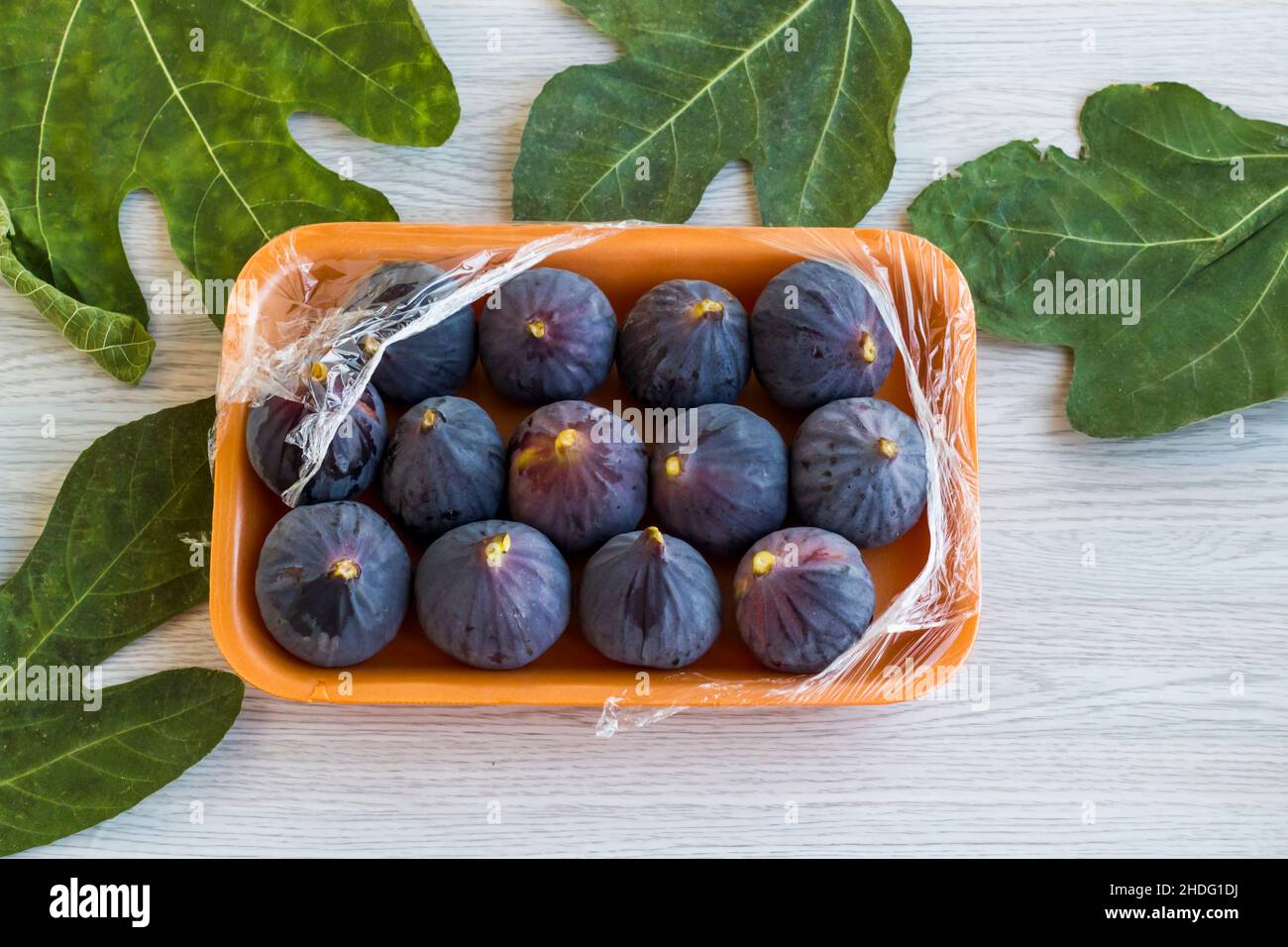 Ripe,fresh figs in its own box on wooden table with fresh,green fig ...
