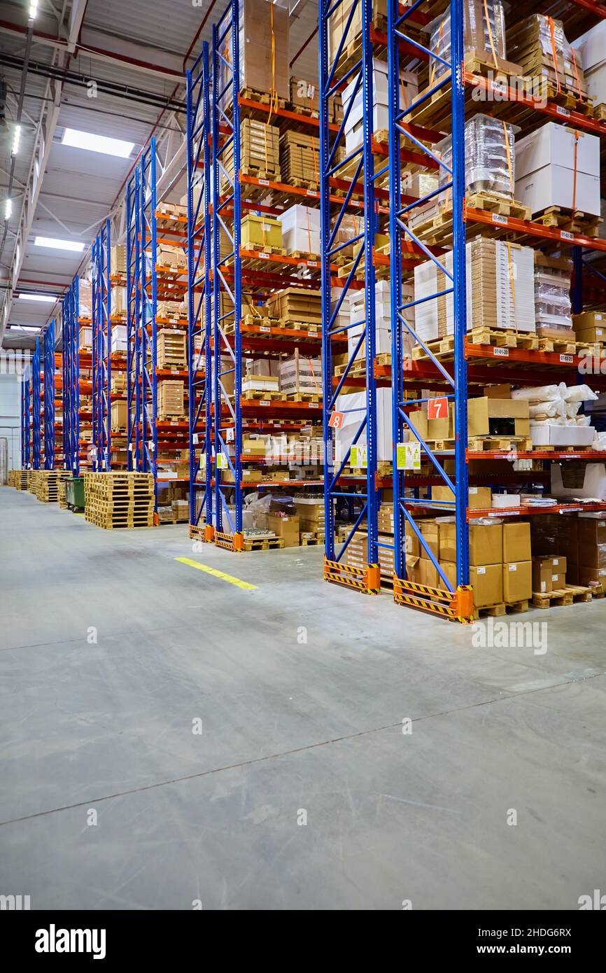 Huge distribution warehouse with high shelves and loaders Stock Photo ...