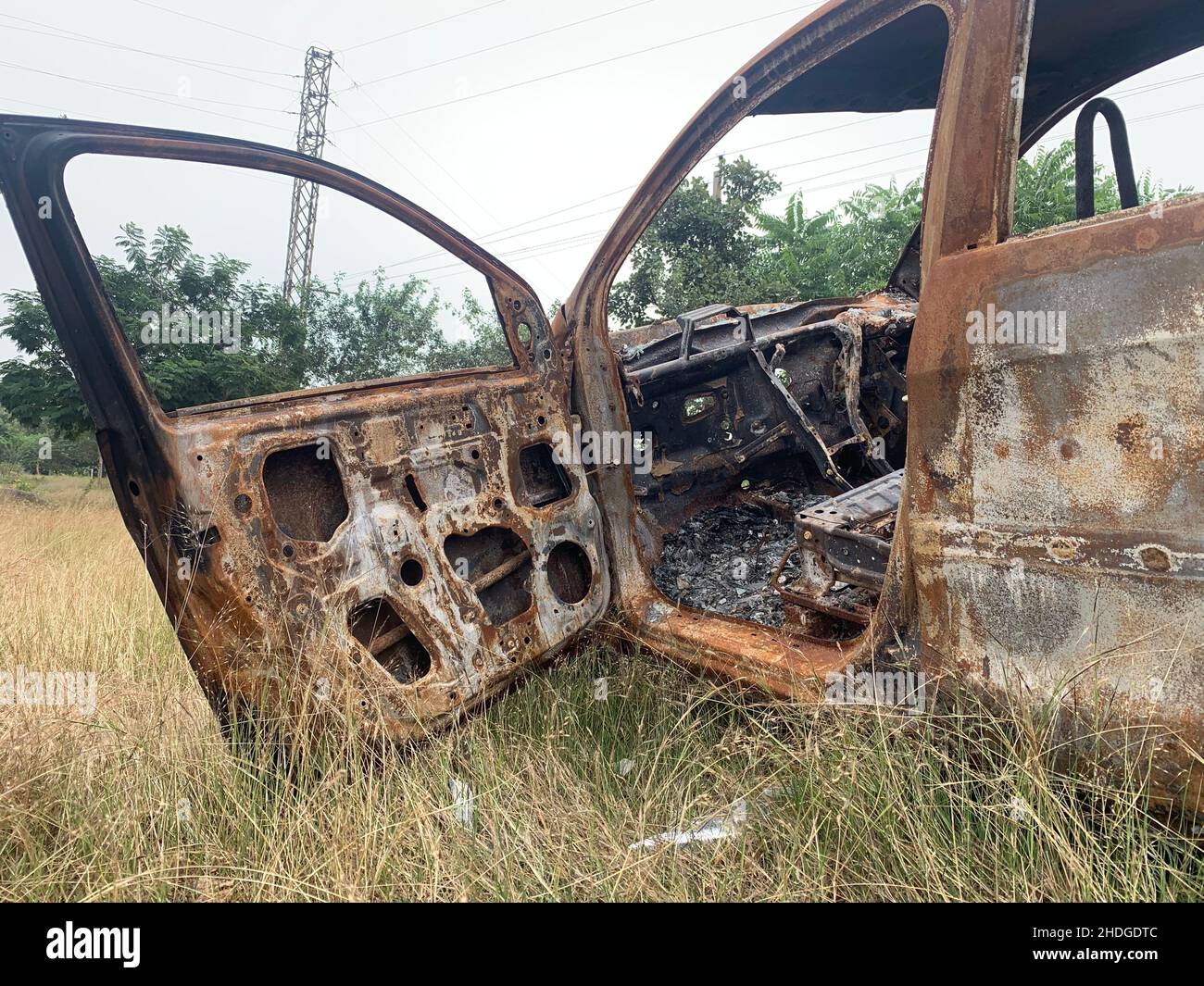 Closeup of the remains of an old crashed car burned from the inside ...