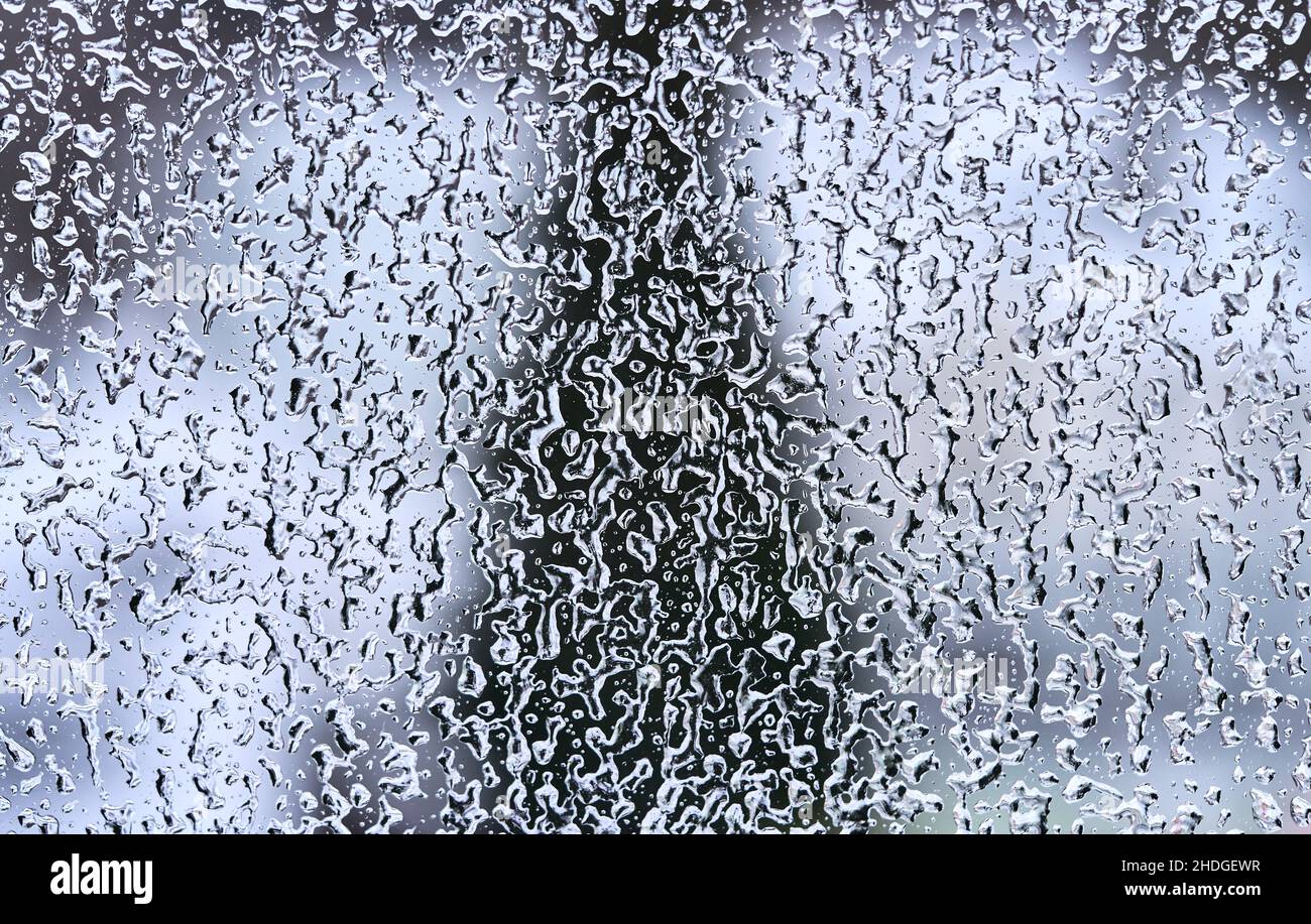 Texture of frozen water drops on the glass. Dark triangle silhouette on ...