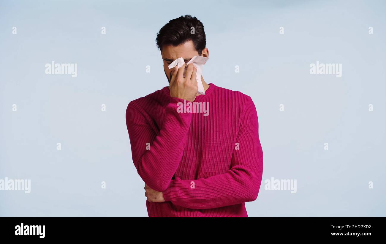 sad man crying and wiping tears with napkin isolated on blue Stock ...
