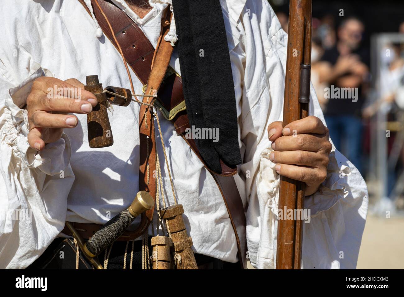 foreground hand showing the loading system of an arquebus. The arquebus ...