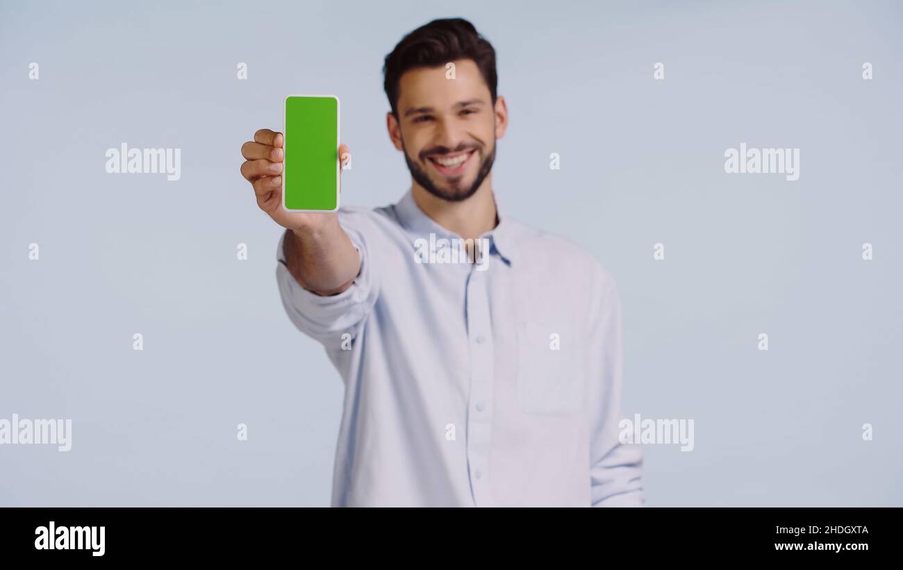 happy man holding cellphone with green screen isolated on blue Stock ...