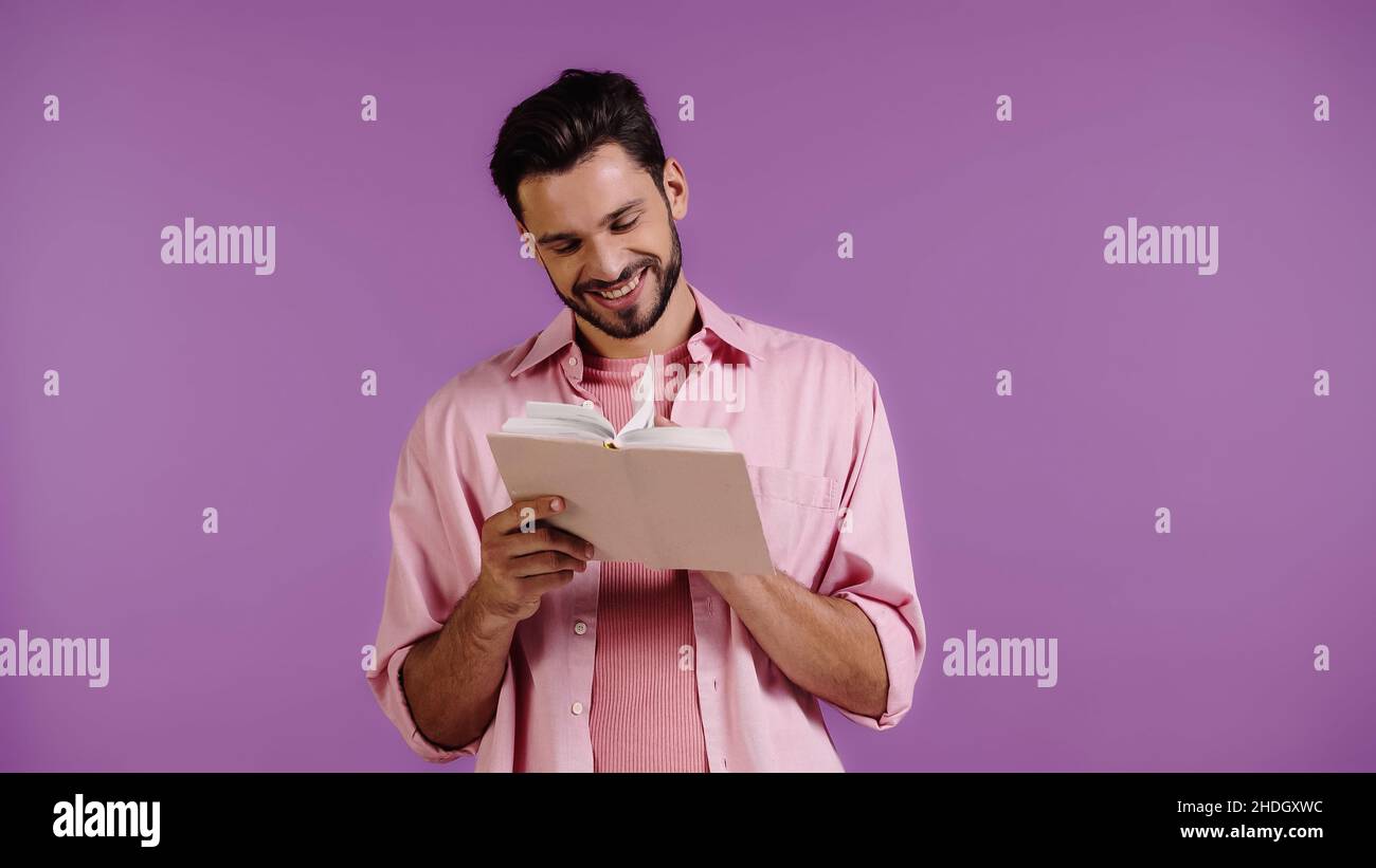 happy bearded man reading book isolated on purple Stock Photo - Alamy