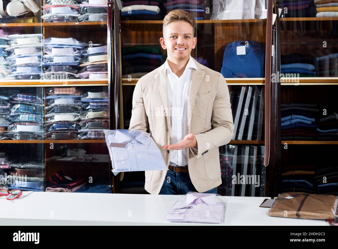 Man seller displaying diverse shirts Stock Photo - Alamy