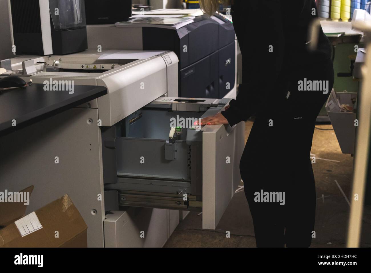 Worker with modern big print machine in print house. Printing industry ...