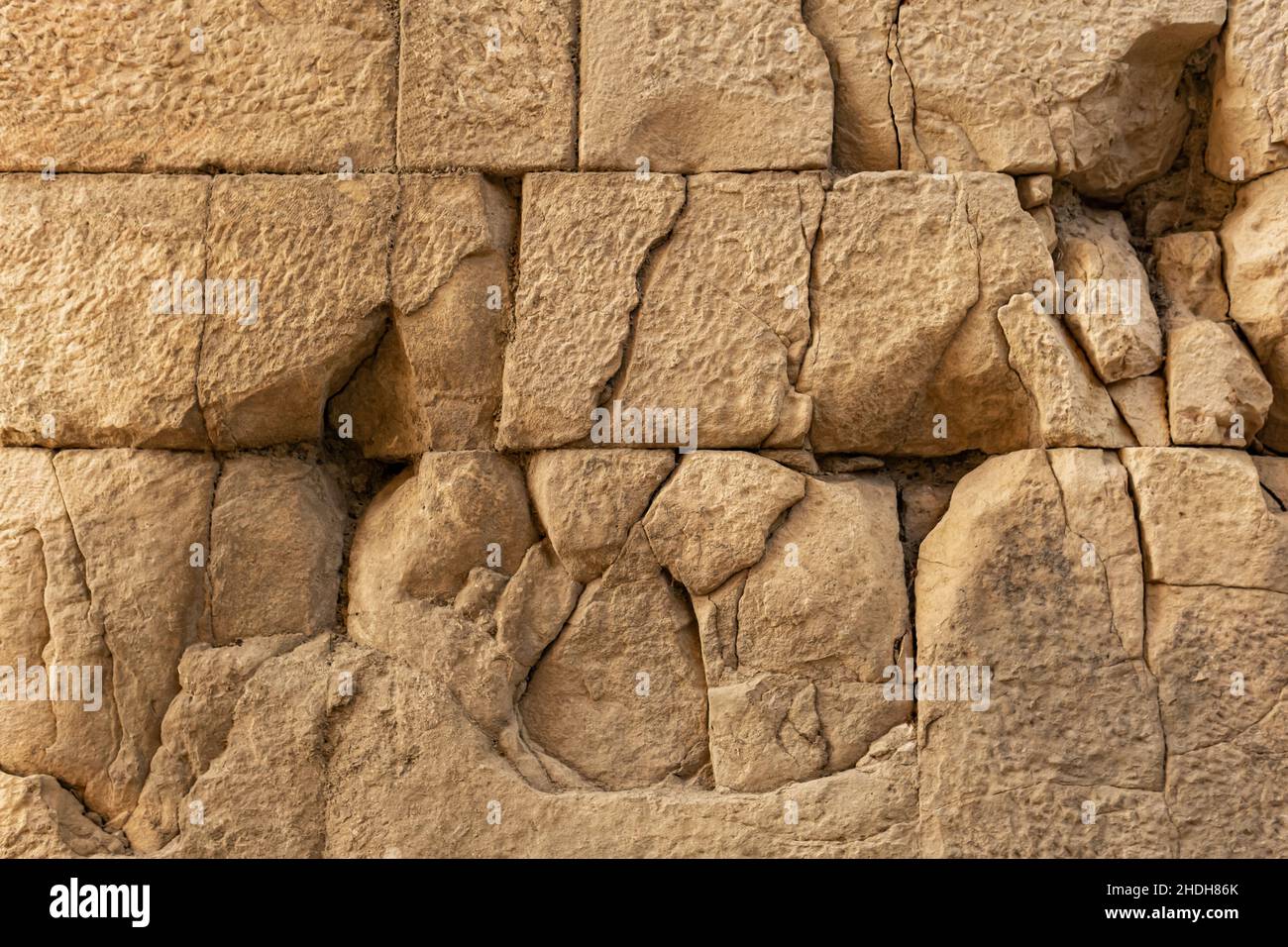 texture of an ancient wall made of huge stone blocks cracked from time ...