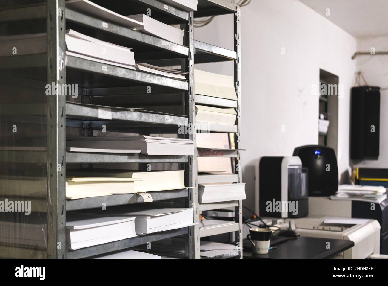 Printing house warehouse and metal shelf with paper. Working process ...
