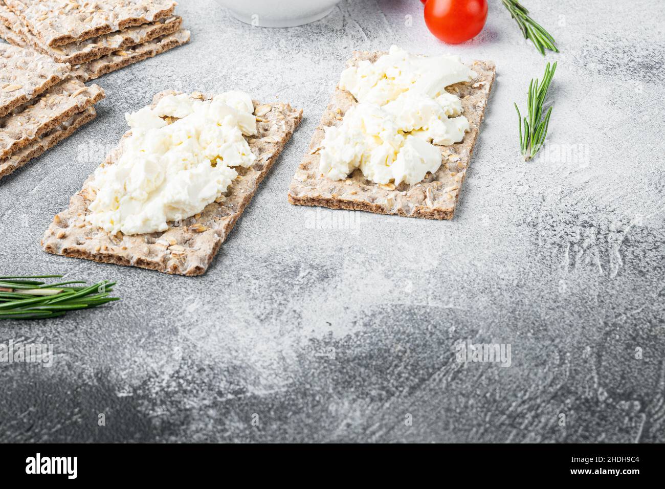 Fresh rye crispbreads with cream cheese set, on gray stone table ...