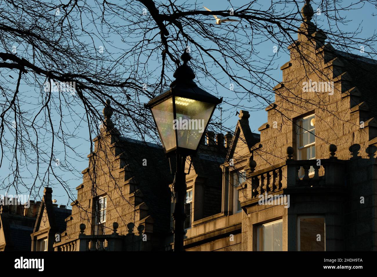 A colour photograph of the tops of buildings and a street lamp on ...