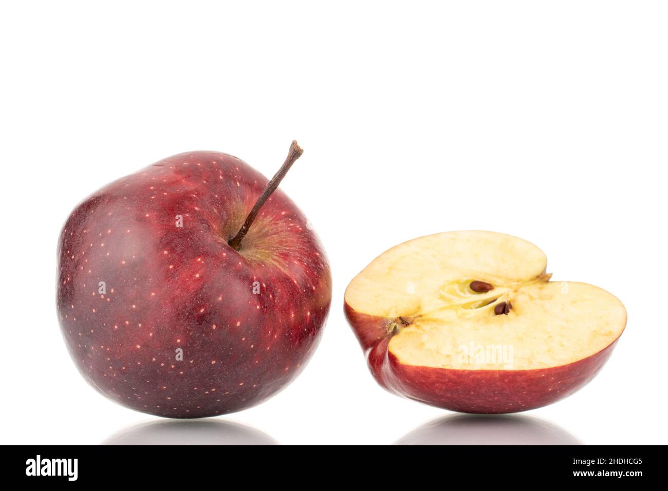 One whole and one half of a ripe red apple, close-up, isolated on white ...