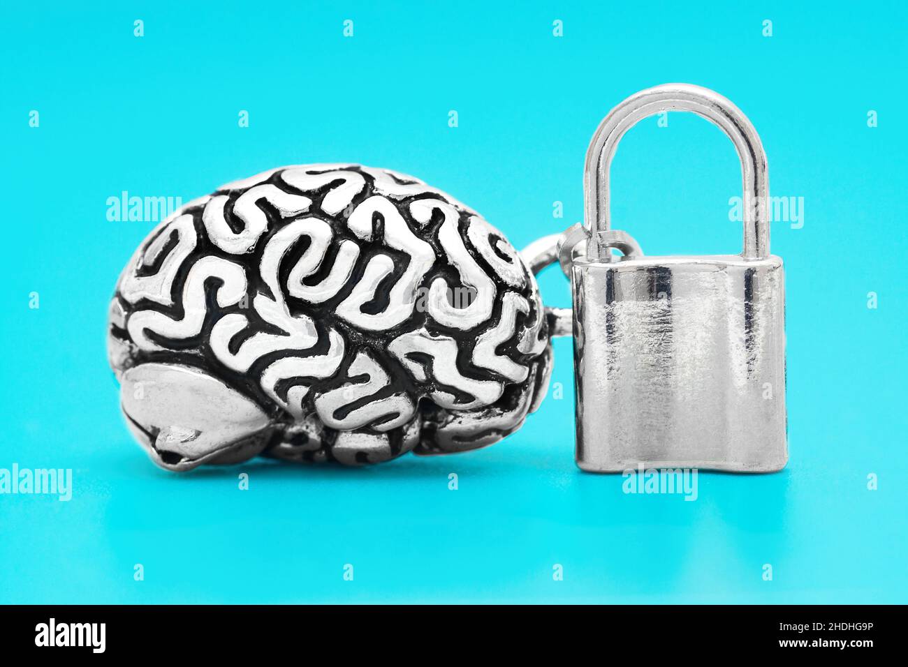Anatomical copy of a human brain with a locked padlock isolated on blue ...