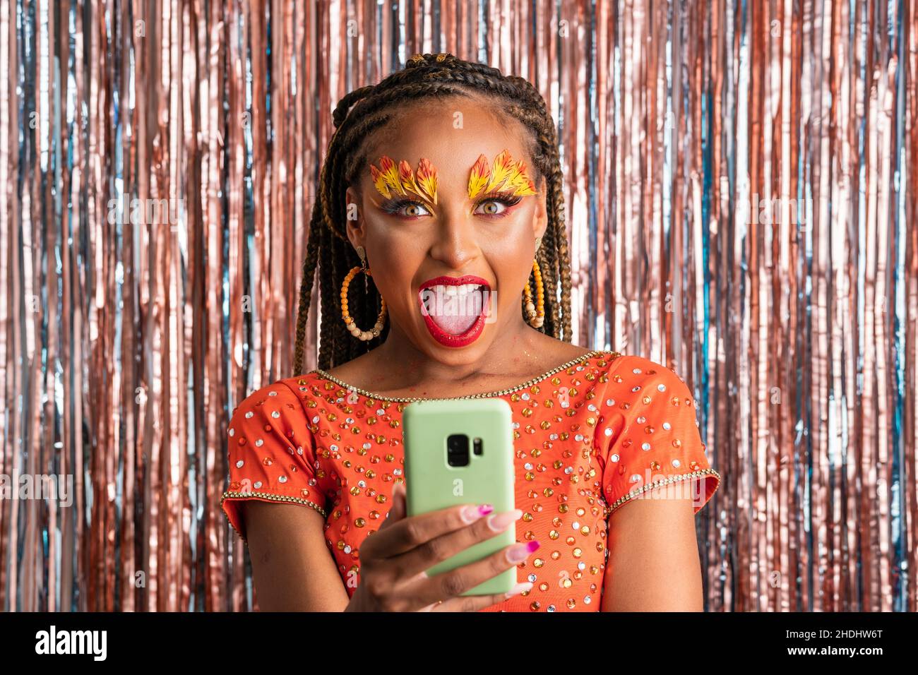 Carnival Party in Brazil, surprised black woman holding mobile on ... Carnival Party in Brazil, surprised black woman holding mobile on ...