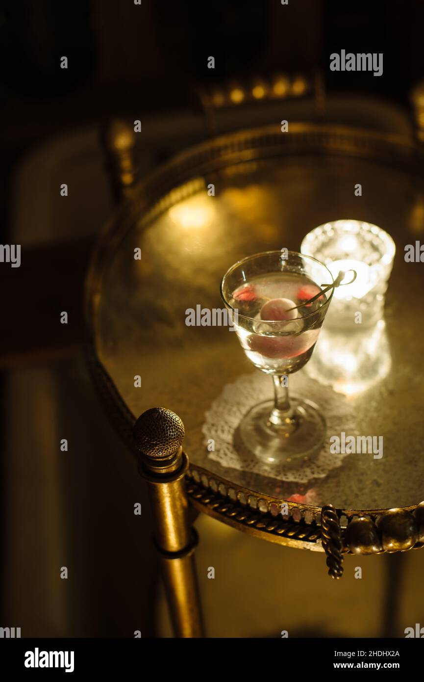 A cocktail on a sidetable by candlelight Stock Photo - Alamy