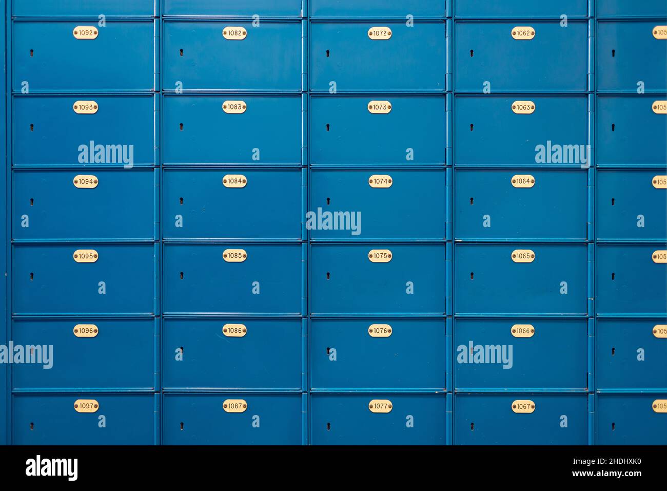 Front view of some blue mail lockers with identification number on a ...