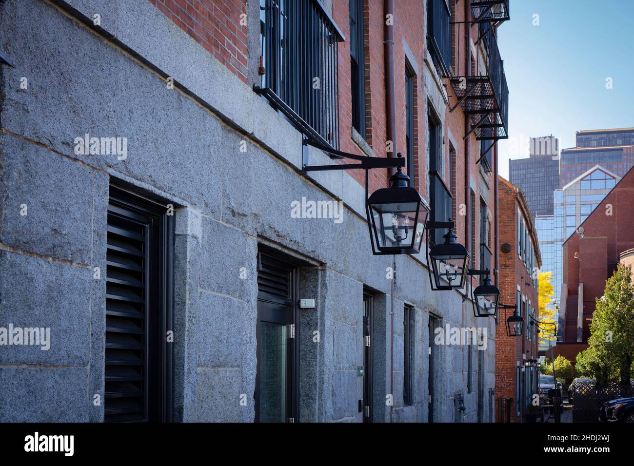 Side view of apartment building facade with hanging lanterns. Stone and ...
