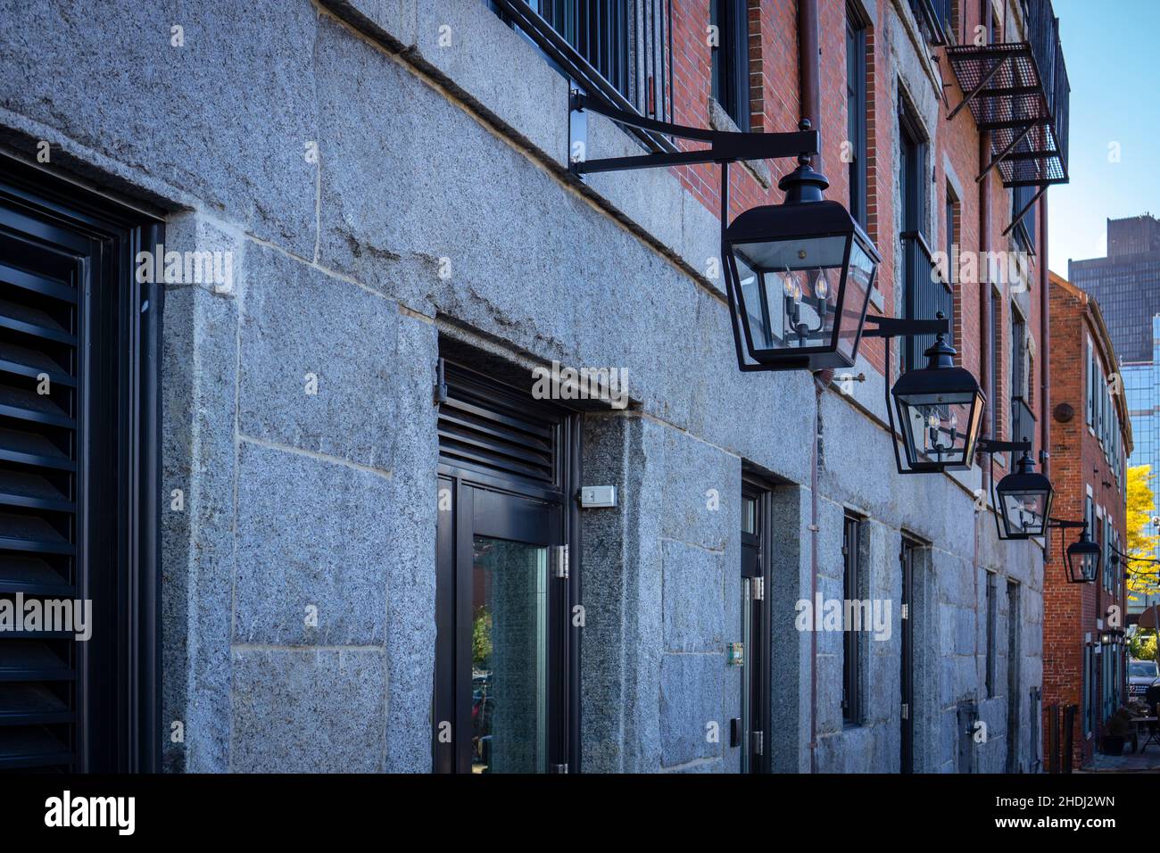 Side view of apartment building facade with hanging lanterns. Stone and ...