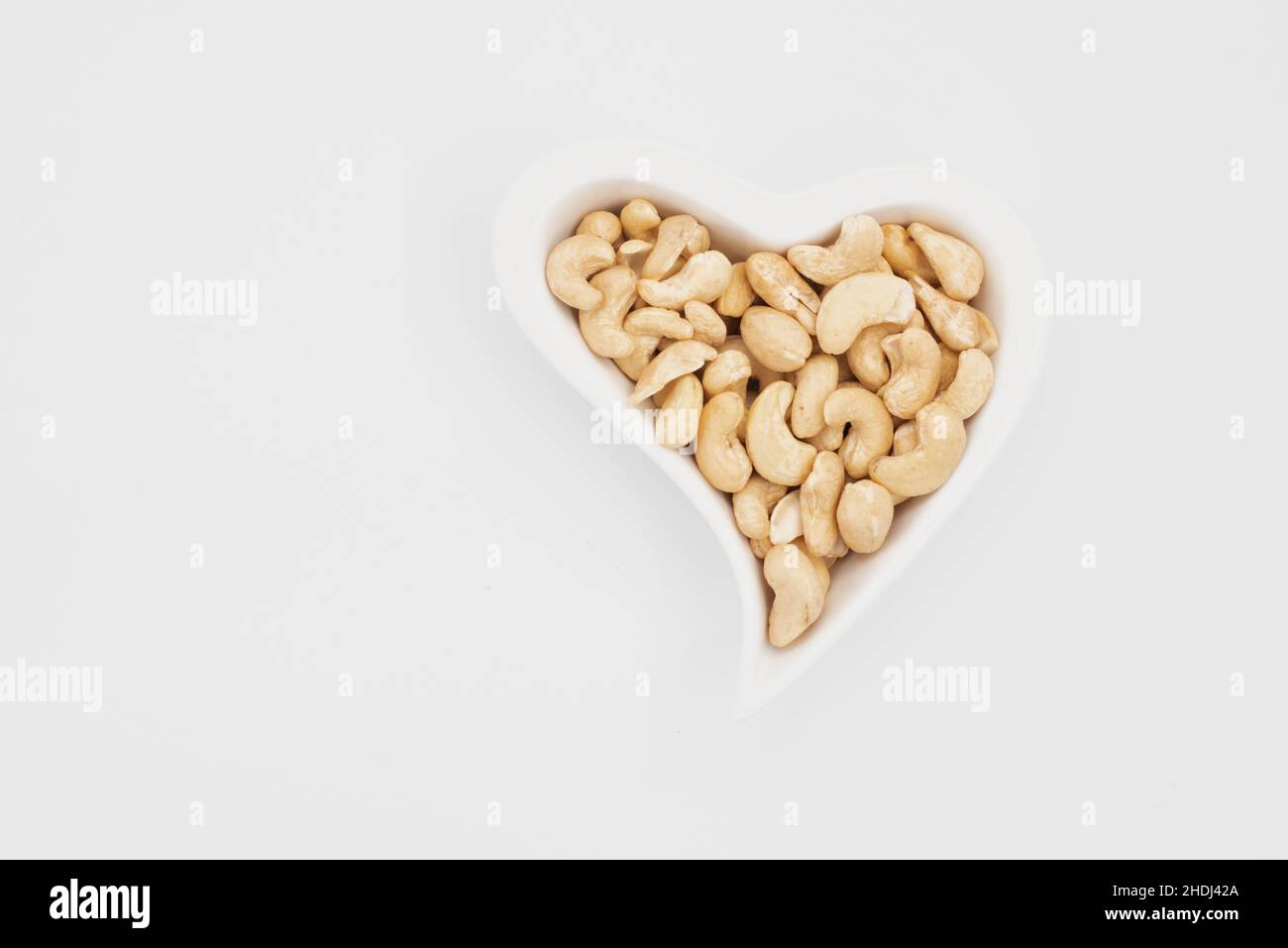 Cashew nuts heart shape plate. Isolated on white background Stock Photo ...