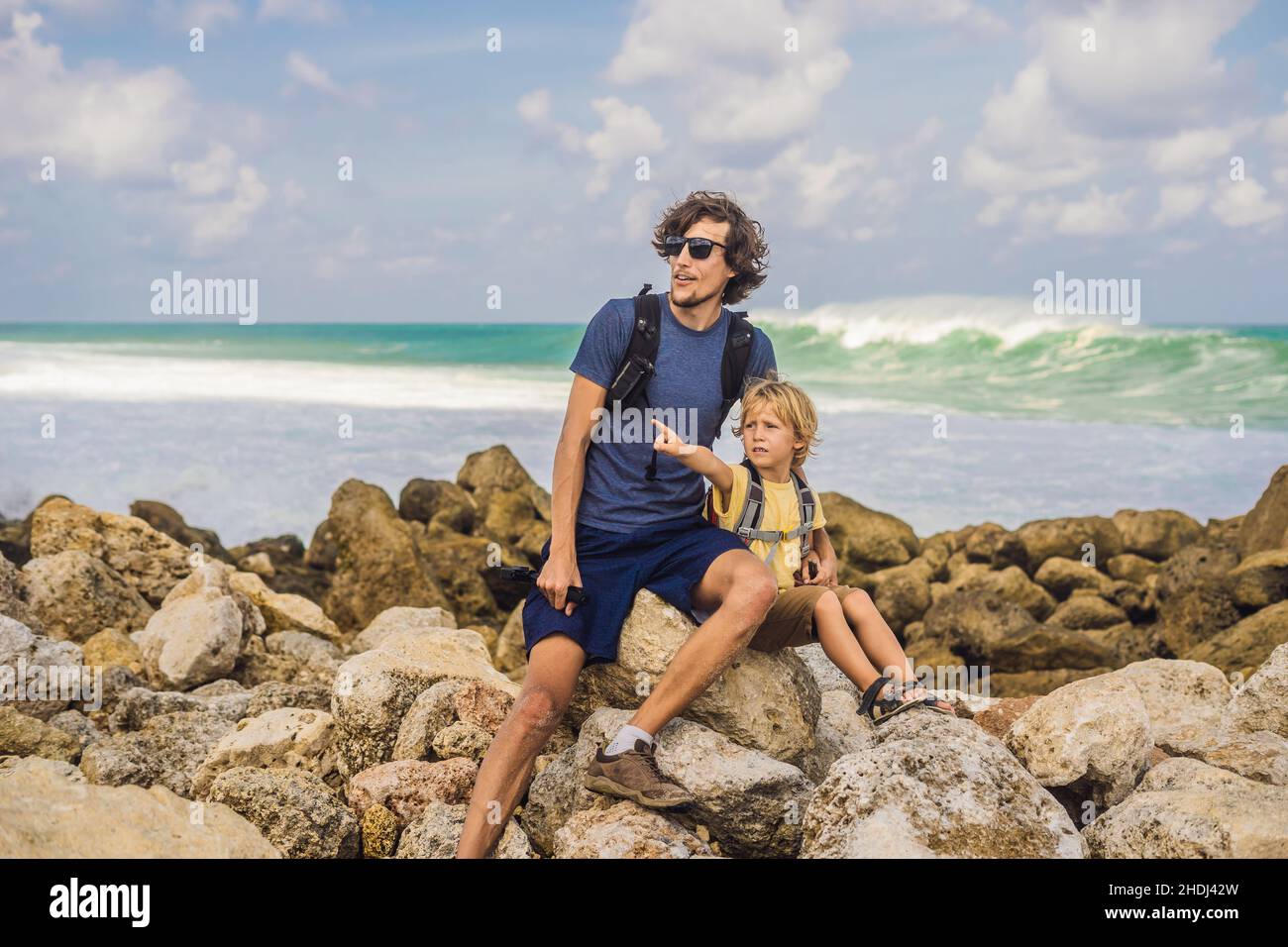 Dad and son travelers on amazing Melasti Beach with turquoise water ...