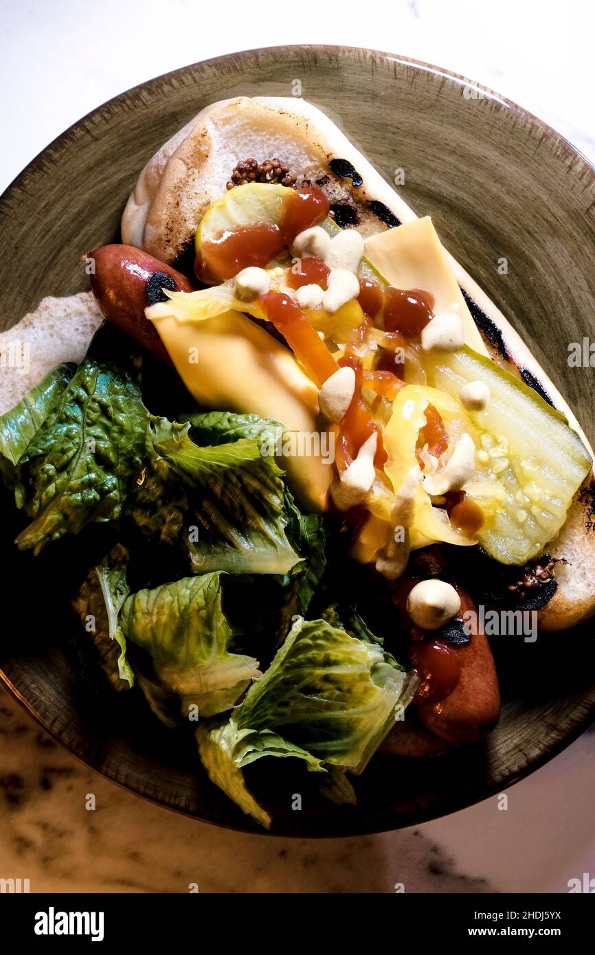 Gourmet the works hot dog on marble kitchen table Stock Photo - Alamy