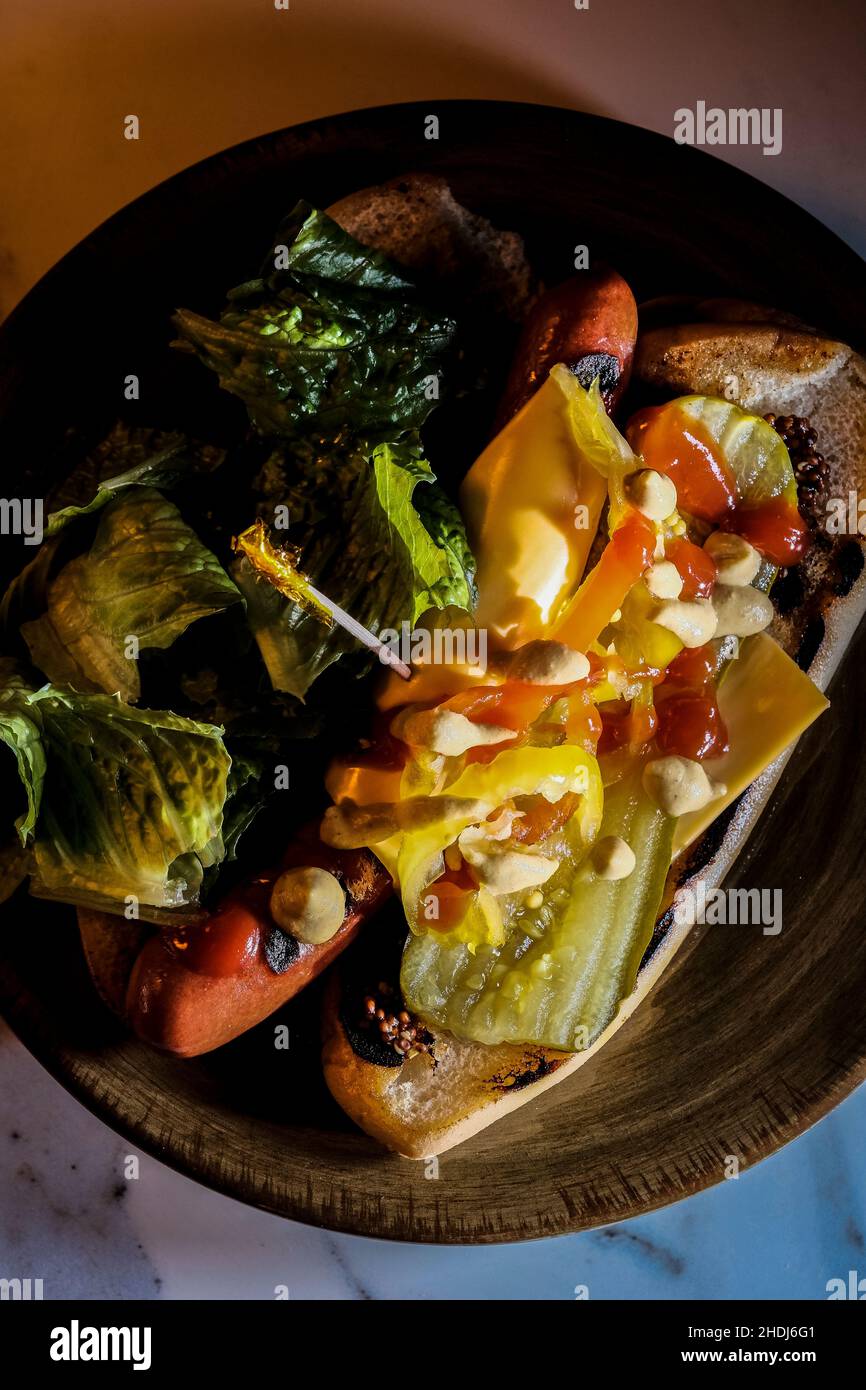 Gourmet the works hot dog on marble kitchen table Stock Photo - Alamy