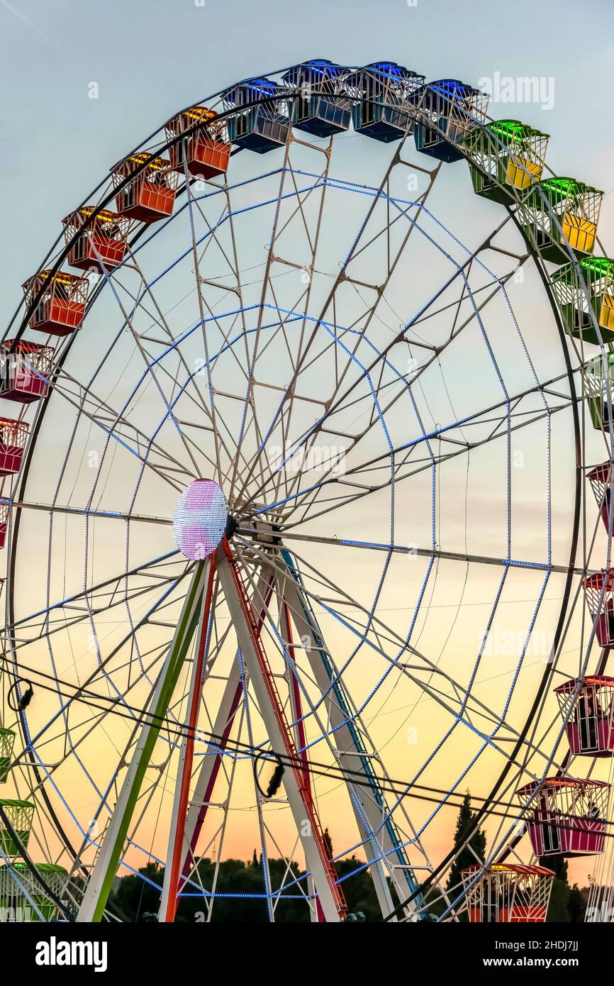 Ferris wheel in a fairground park next to a carousel Stock Photo - Alamy