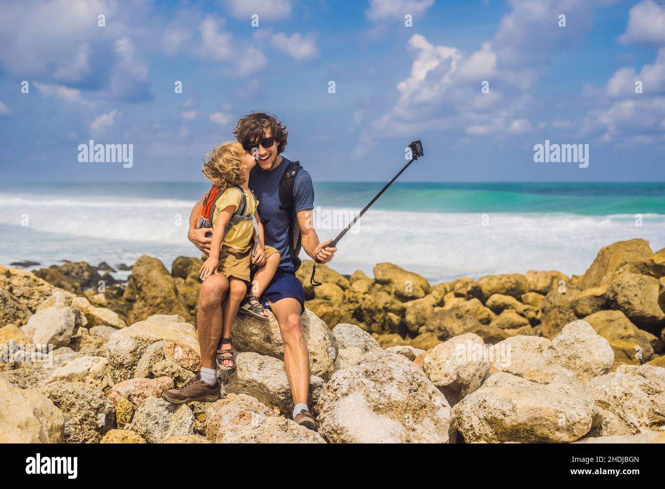 Dad and son travelers on amazing Melasti Beach with turquoise water ...