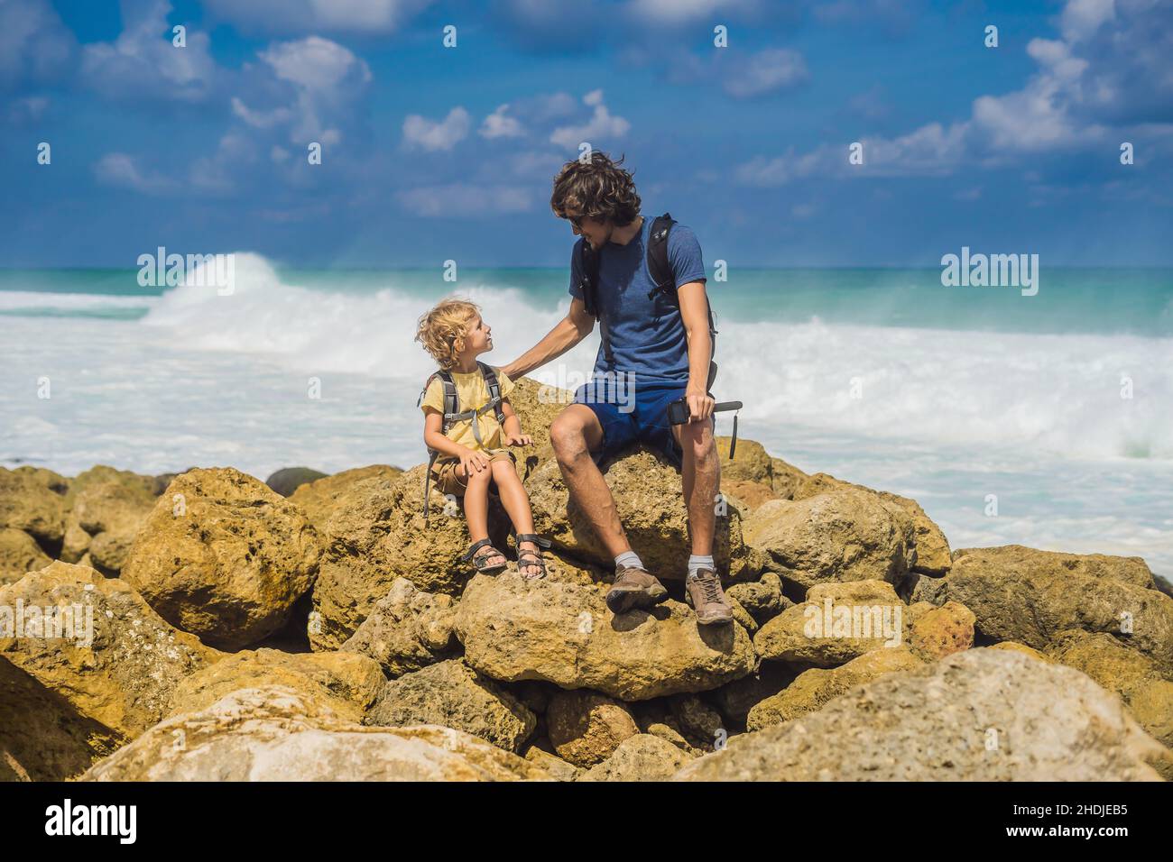 Dad and son travelers on amazing Melasti Beach with turquoise water ...