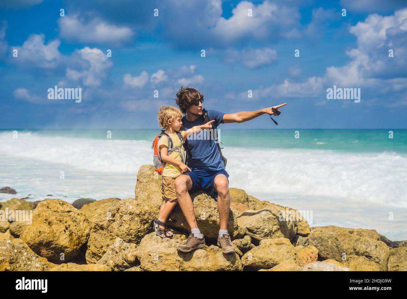 Dad and son travelers on amazing Melasti Beach with turquoise water ...