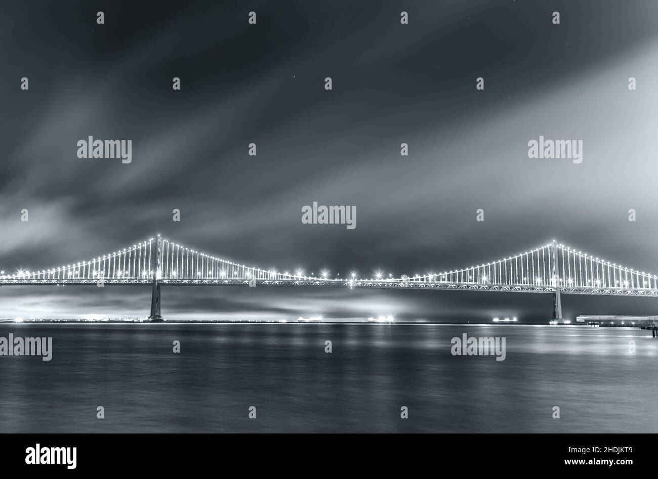 A nighttime photograph captures the iconic Bay Bridge in San Francisco ...