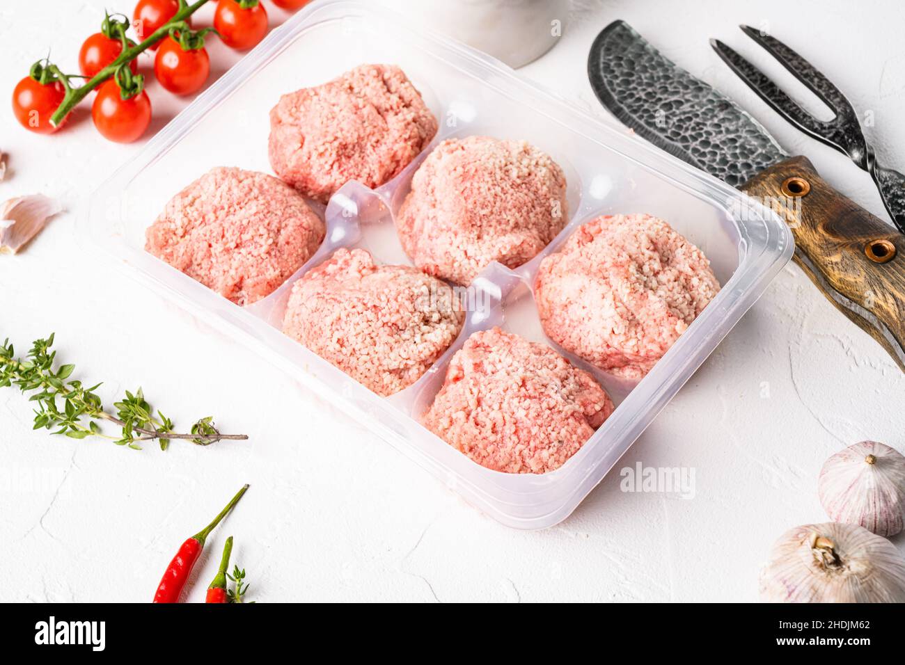 Raw turkey meatballs in plastic disposable tray set, on white stone ...