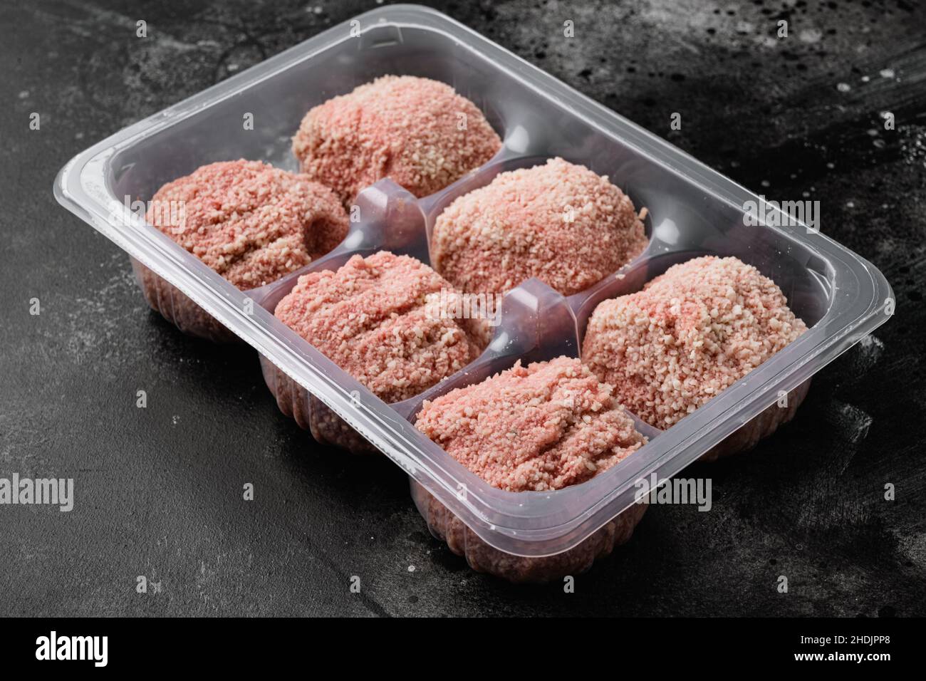 Raw turkey meatballs in plastic disposable tray set, on black dark ...