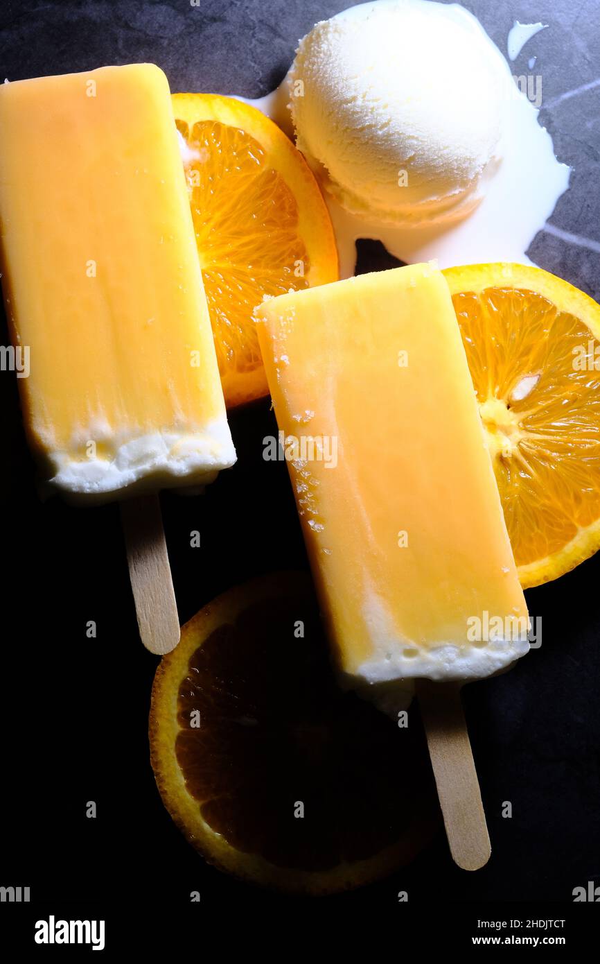Oranges and cream vanilla ice pops melting on kitchen counter Stock ...