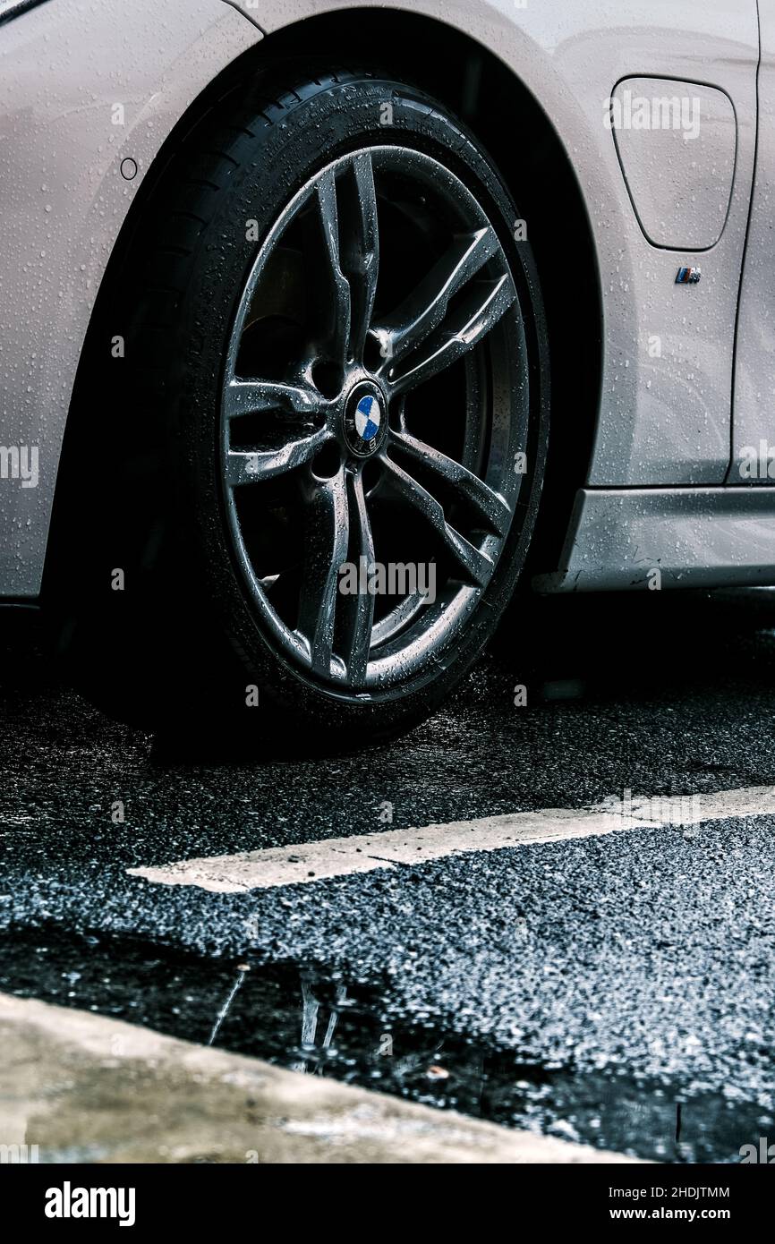 Vertical shot of a front-wheel with BMW logo on a white BMW 330e car ...