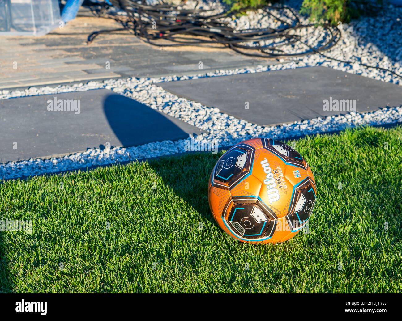 Orange Wilson soccer ball in a garden Stock Photo - Alamy
