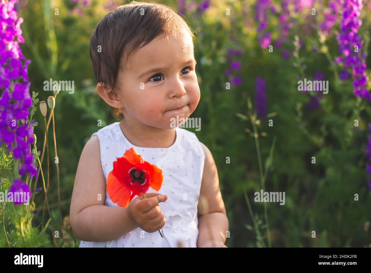 Emotional child outdoor portrait of nice little girl in white dress ...